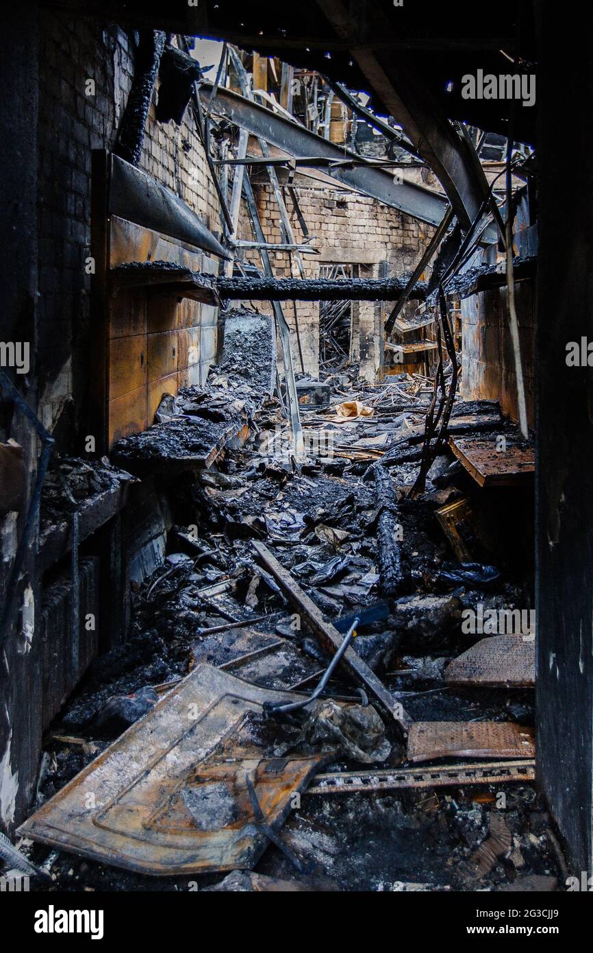 Burnt out shop after fire with charred walls and remains of furniture ...