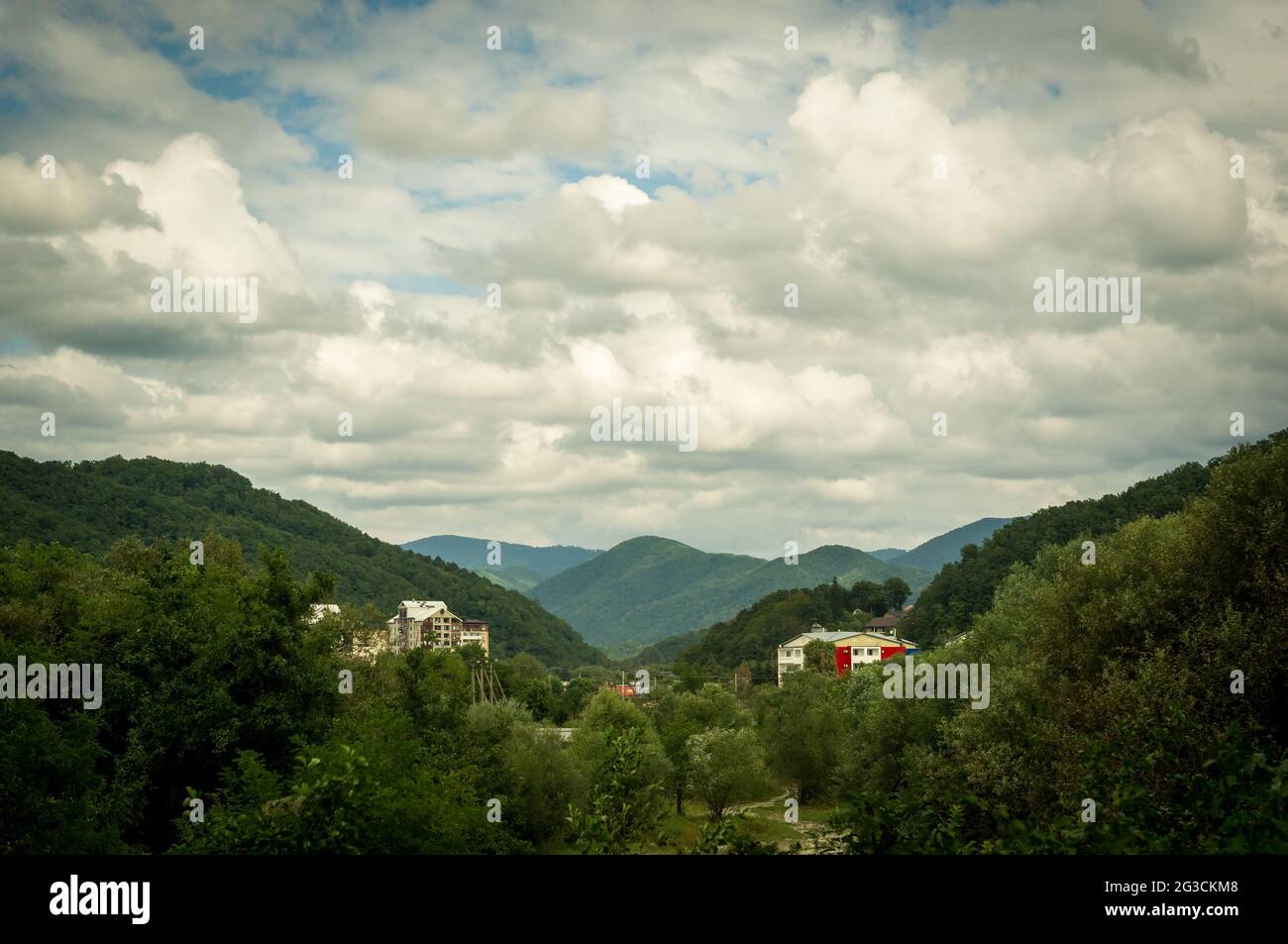 Resort village in mountain valley against the blue sky with clouds ...