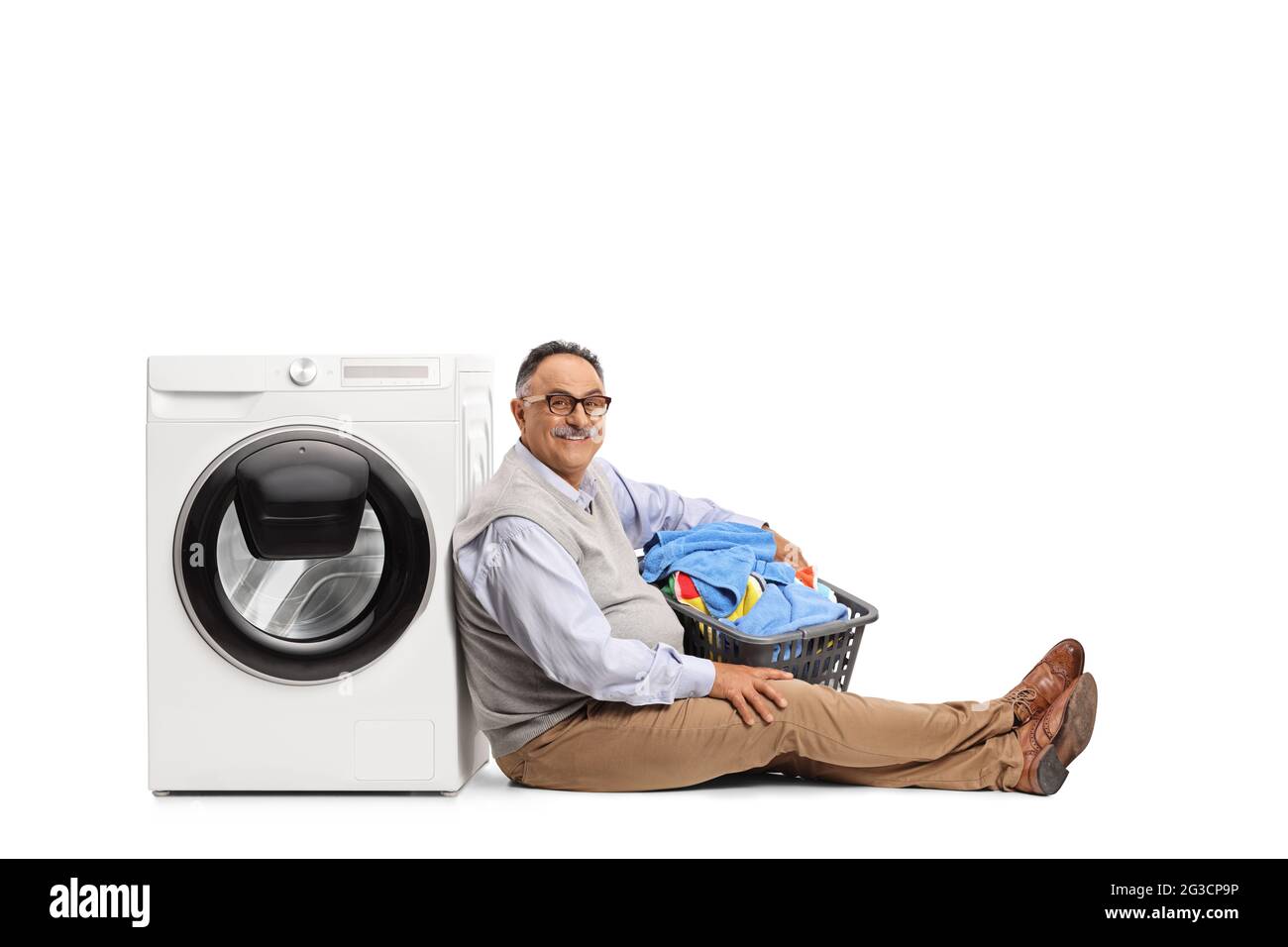 Mature man sitting with a laundry basket and leaning on a washing ...