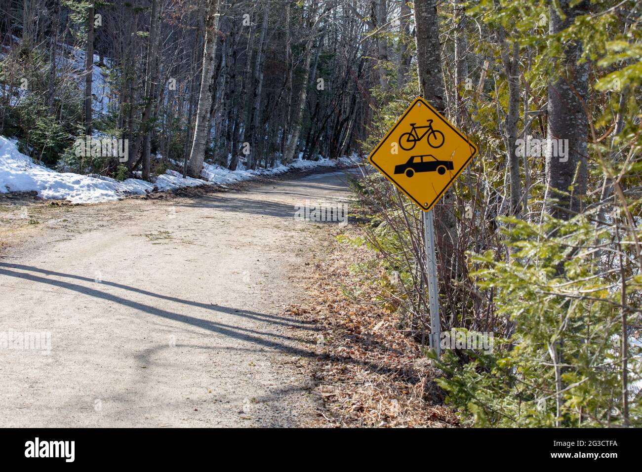 yellow sign on the side of a paved road asking to share the road with a ...