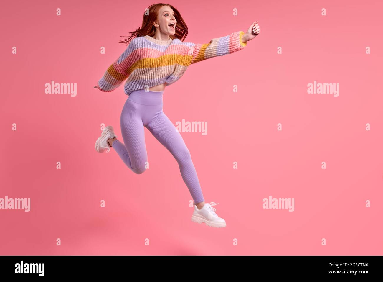 Adorable cute funny woman jumping up in studio, caucasian lady raising ...