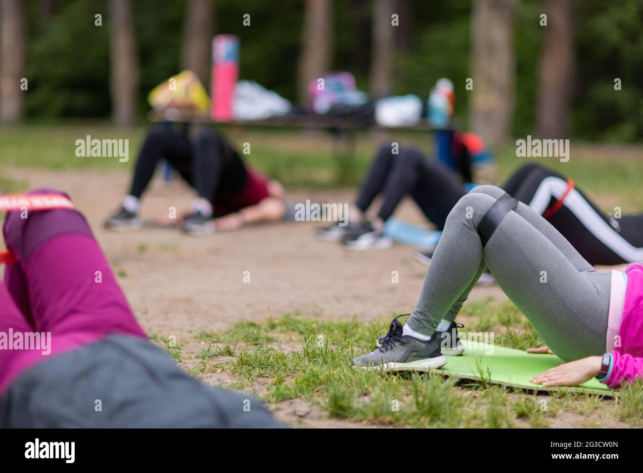 Group stretching workout - three cute girls stretches outdoors on a ...