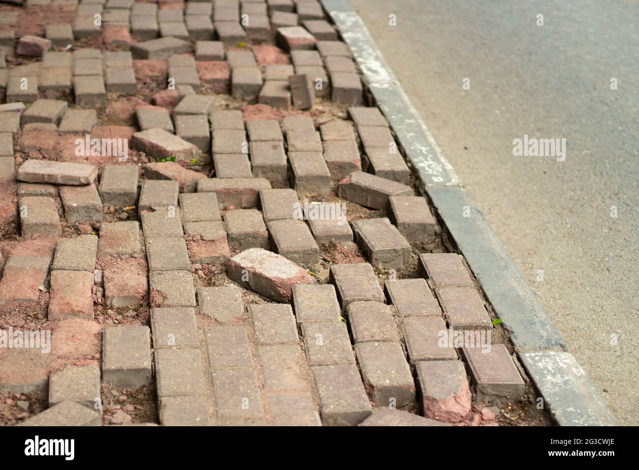 Broken paving stones on the road. The masonry is broken. The pedestrian ...