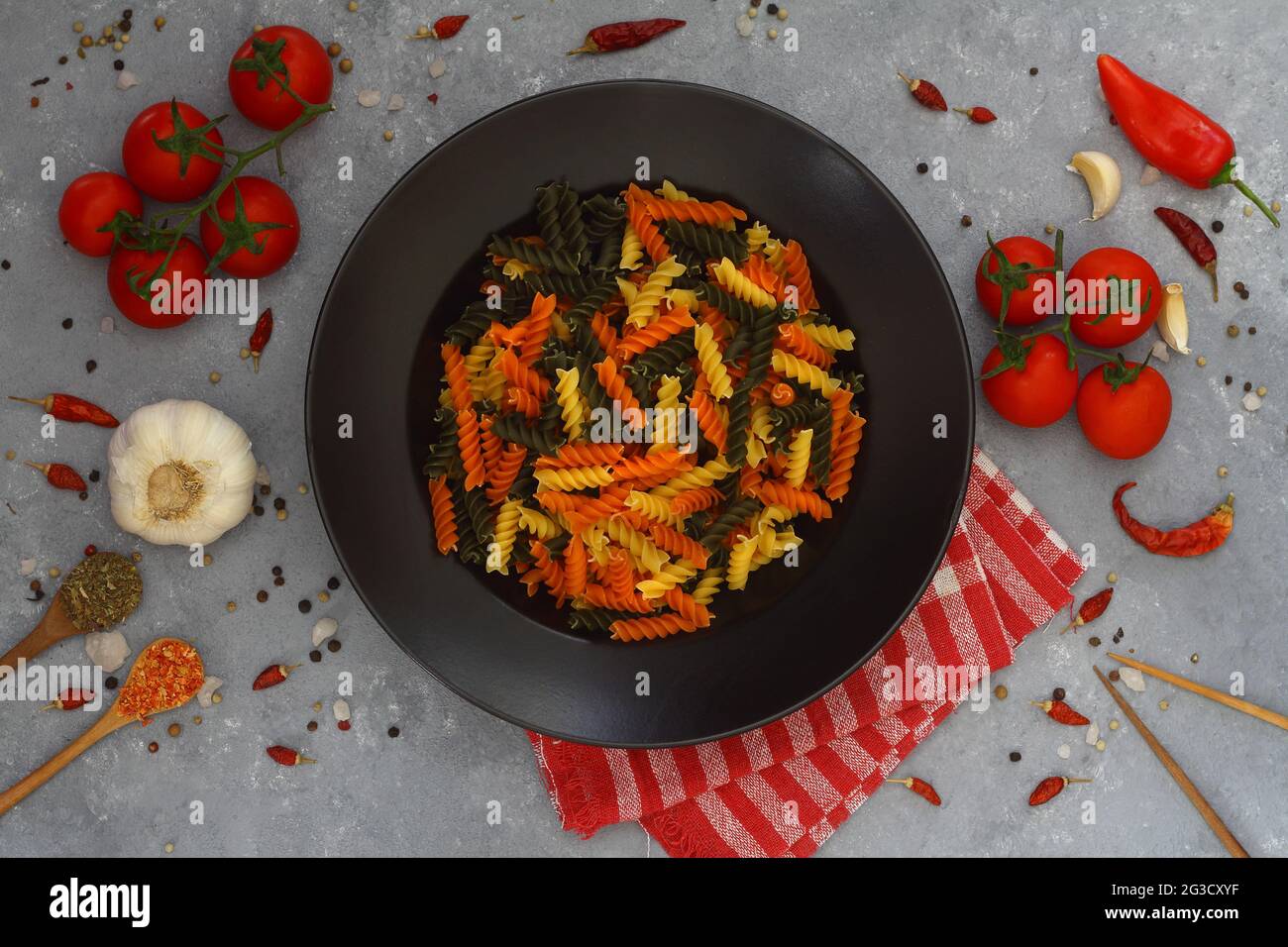 Colorful various raw fusilli on black plate Stock Photo - Alamy