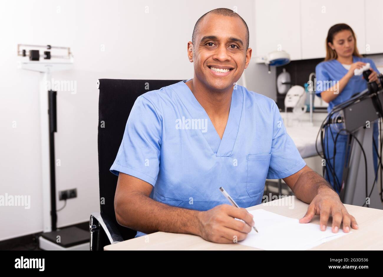 Male cosmetologist working with documents in aesthetic medicine office ...