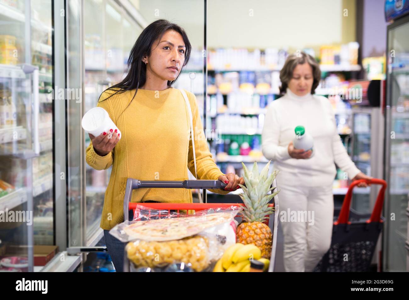 Hispanic woman shopping for milk products in supermarket Stock Photo ...
