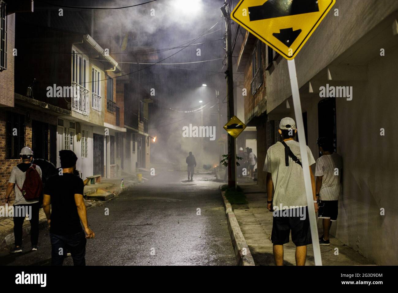 Demonstratros throw rocks and debree as a tear gas cloud fills a street ...