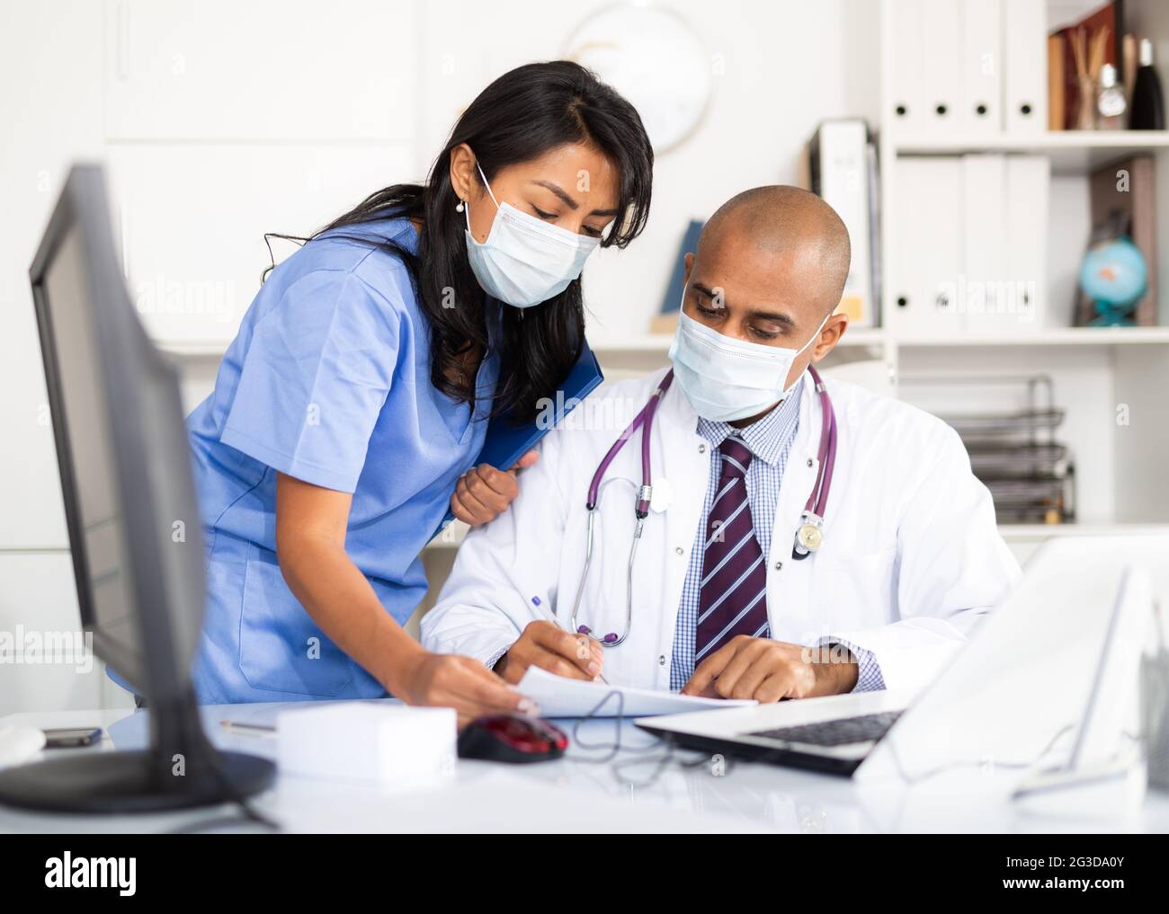 Doctor giving instructions to the secretary in office Stock Photo - Alamy