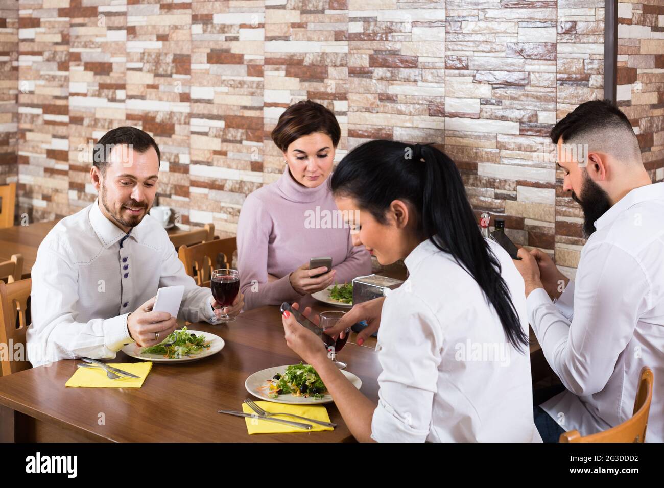 group of friends busy with phone in restaurant Stock Photo - Alamy