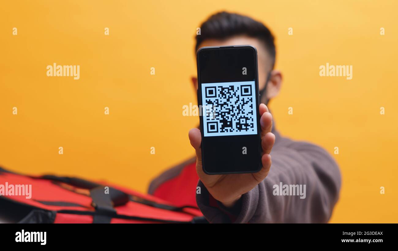 Delivery man holding a red parcel box. Showing mobile phone screen in ...