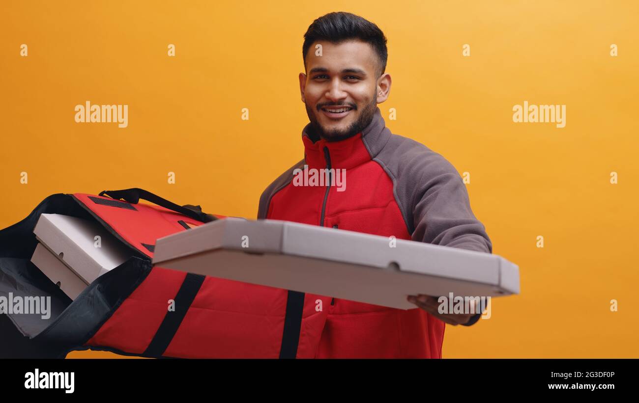 Delivery boy wearing mask carrying pizza boxes in his red parcel box ...