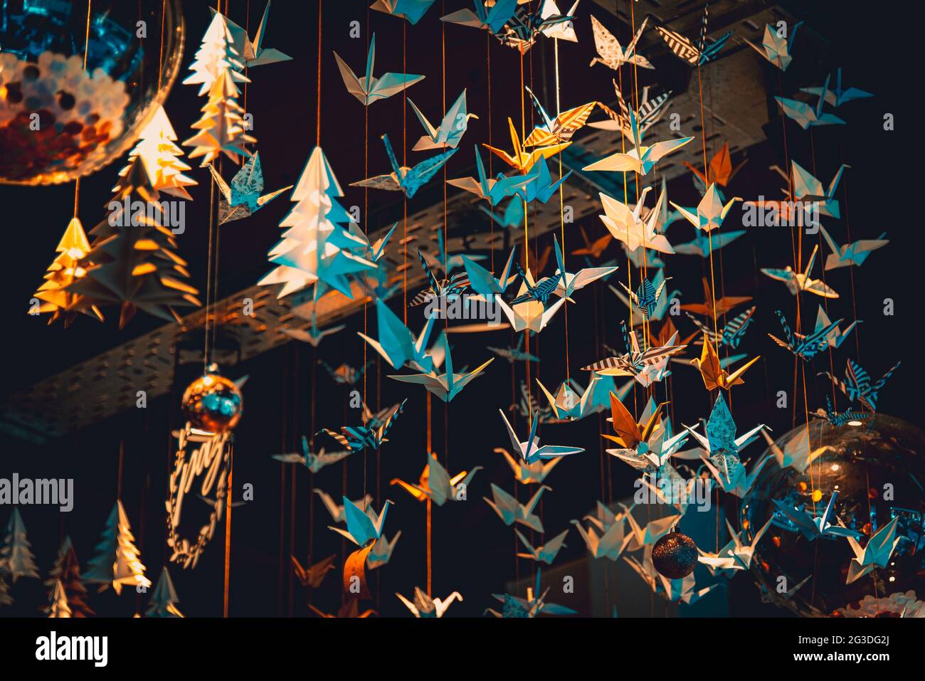 Lots of origami swans hanging from the roof, seen from underneath in a ...