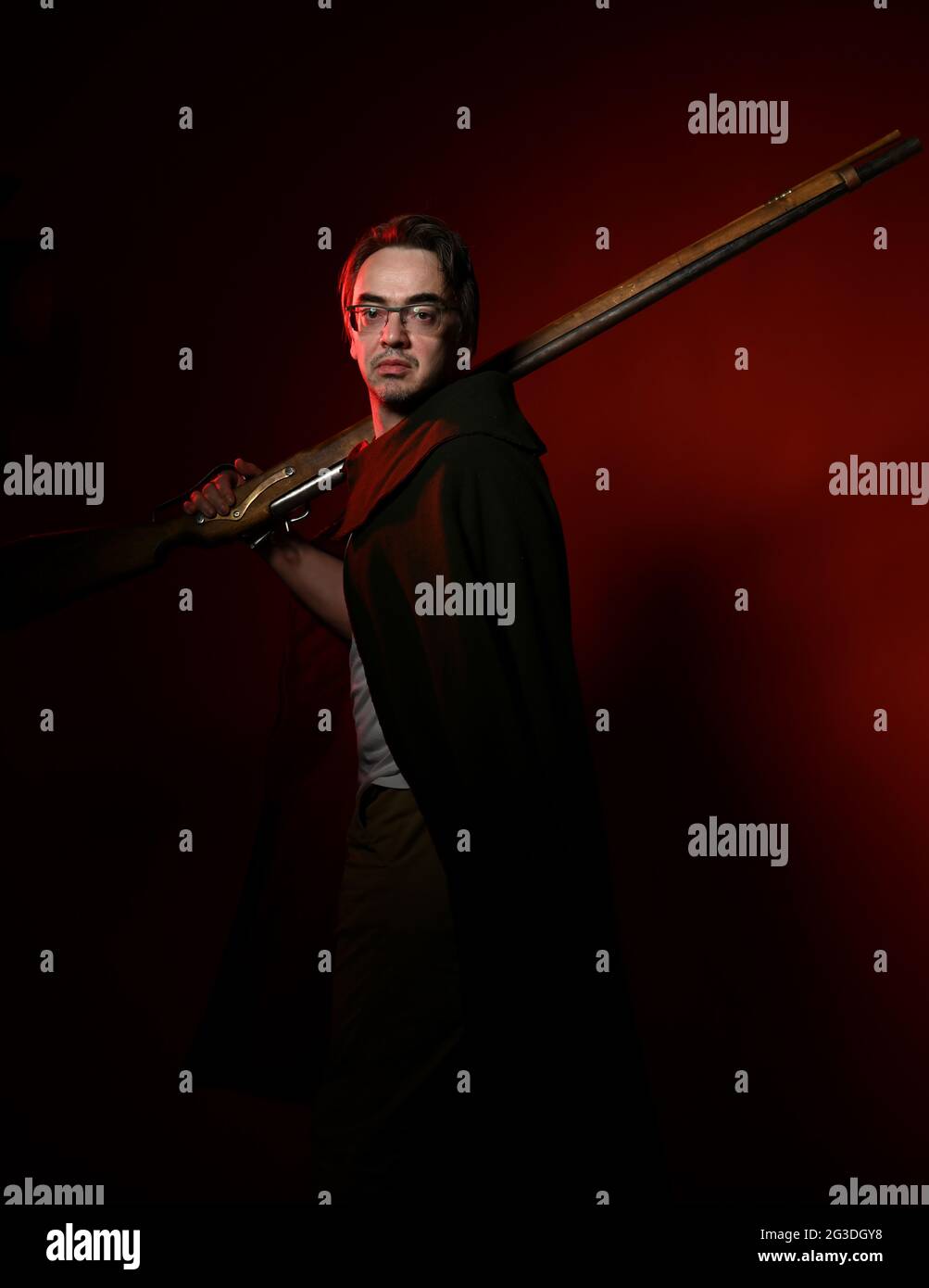 Soldier in cape at night watch, patrol walking with his rifle slung ...