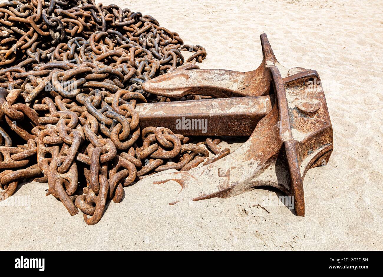 Huge rusty anchor chains with ship anchor of an old ship on the sand ...