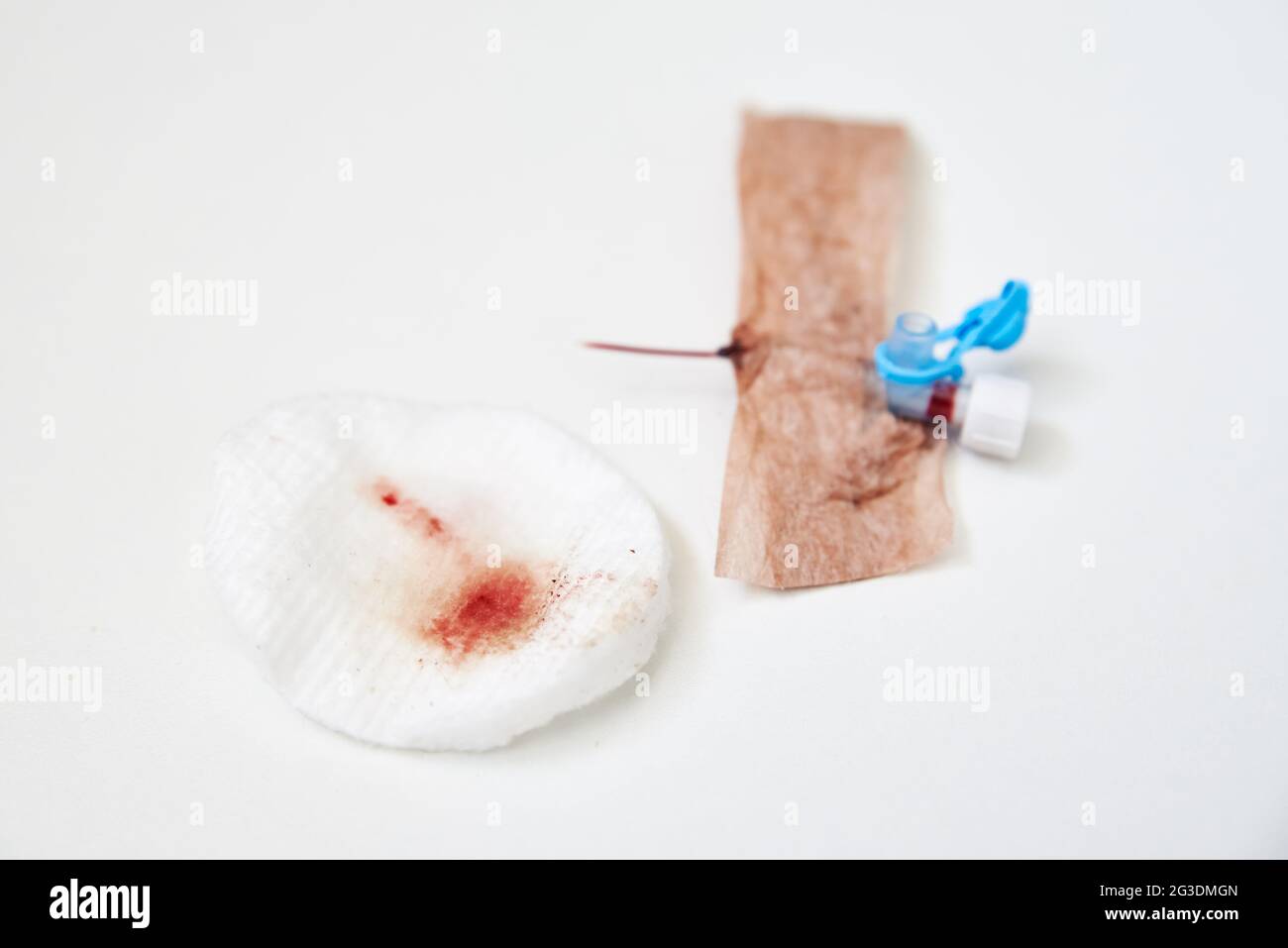 Used catheter, bandage and cotton pad with blood on white background ...