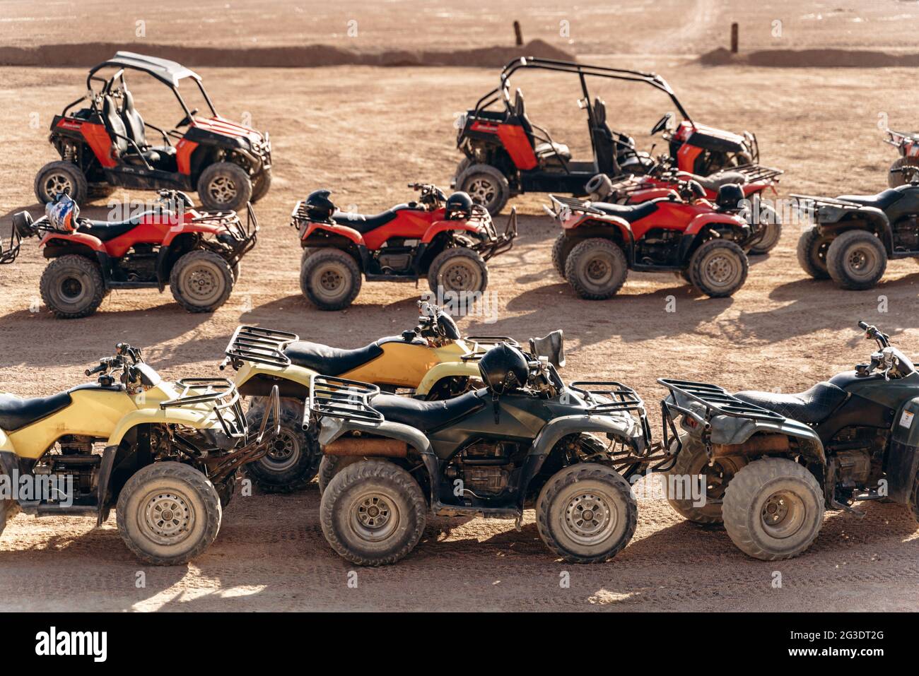 Large column of ATVs and buggies stands in the middle of a sandy desert ...