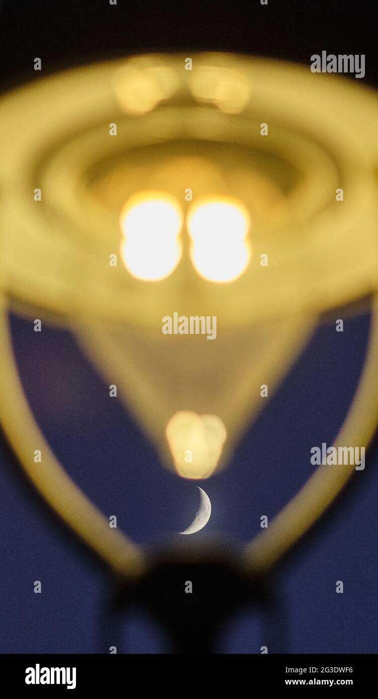 Berlin, Germany. 15th June, 2021. The moon shines as a crescent behind ...