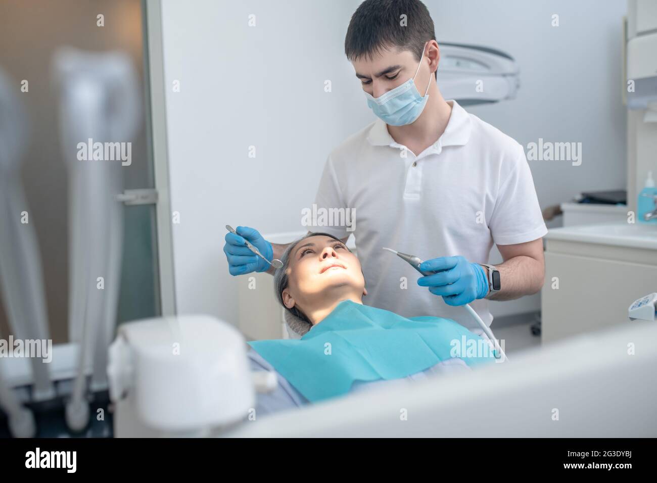 Male dentist working with a patient and making teeth restoration Stock ...