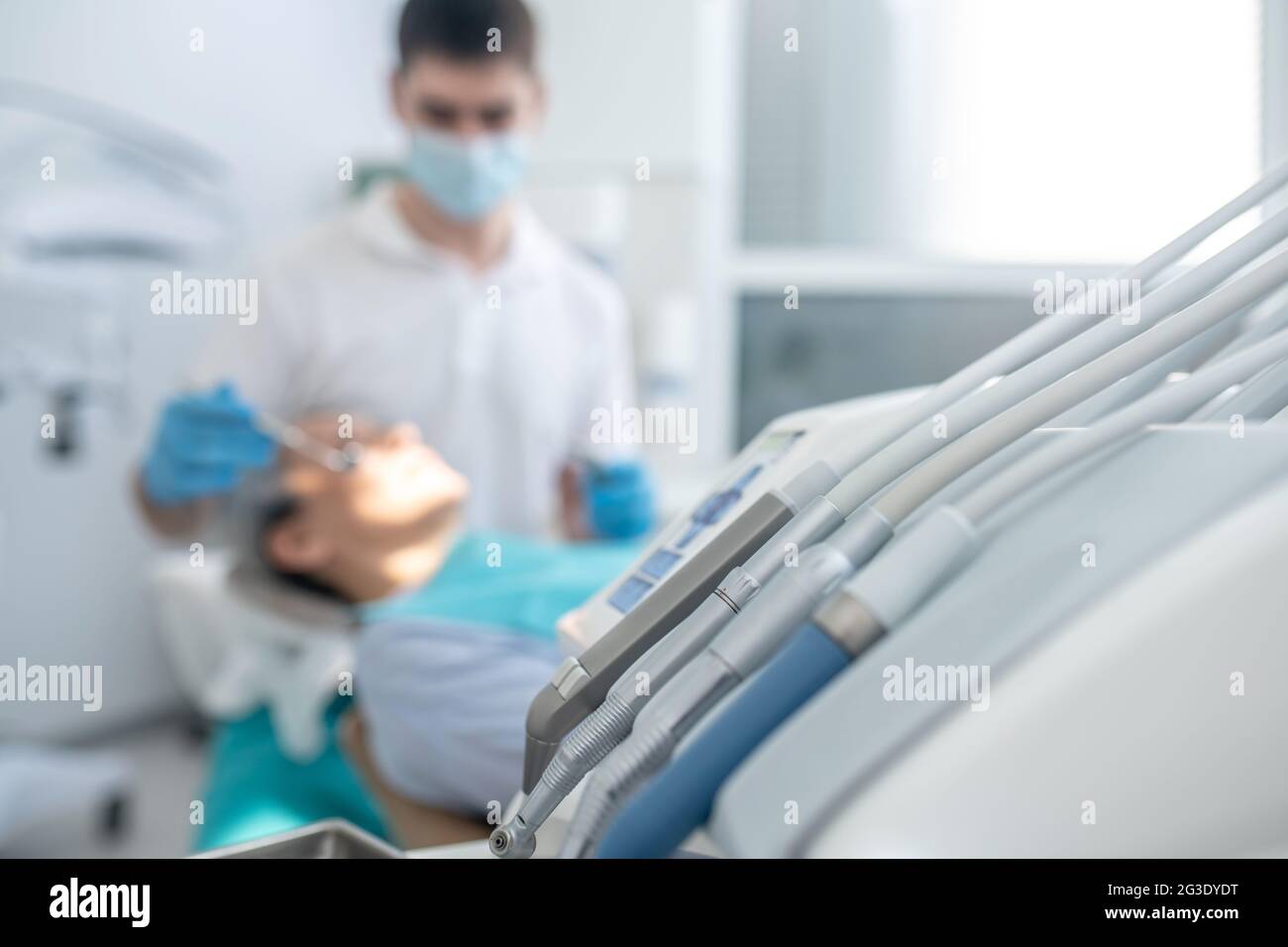 Male dentist working with a patient and making teeth restoration Stock ...