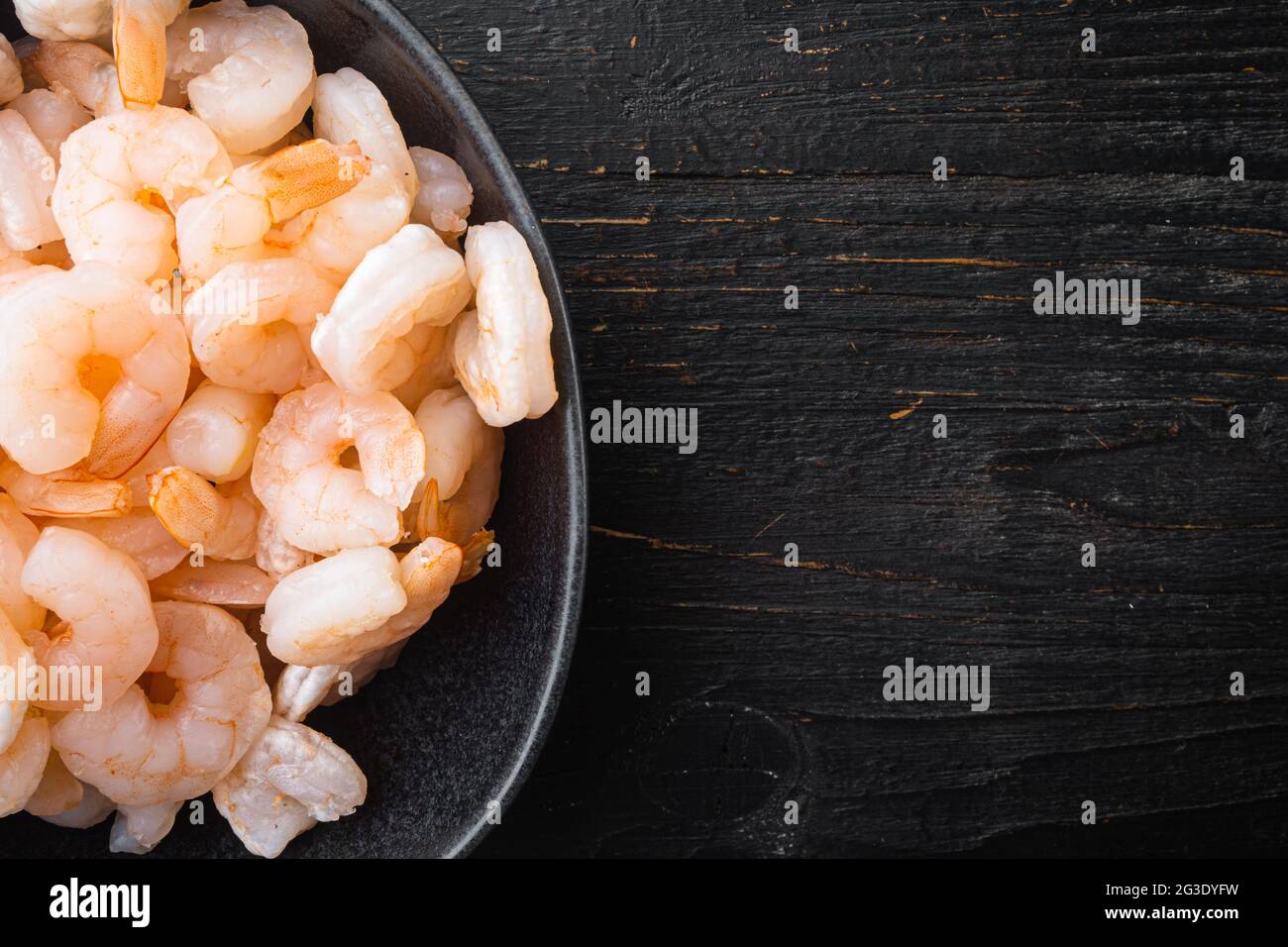 Boiled Peeled Shrimps, Prawns set, in bowl, on black wooden table, top ...