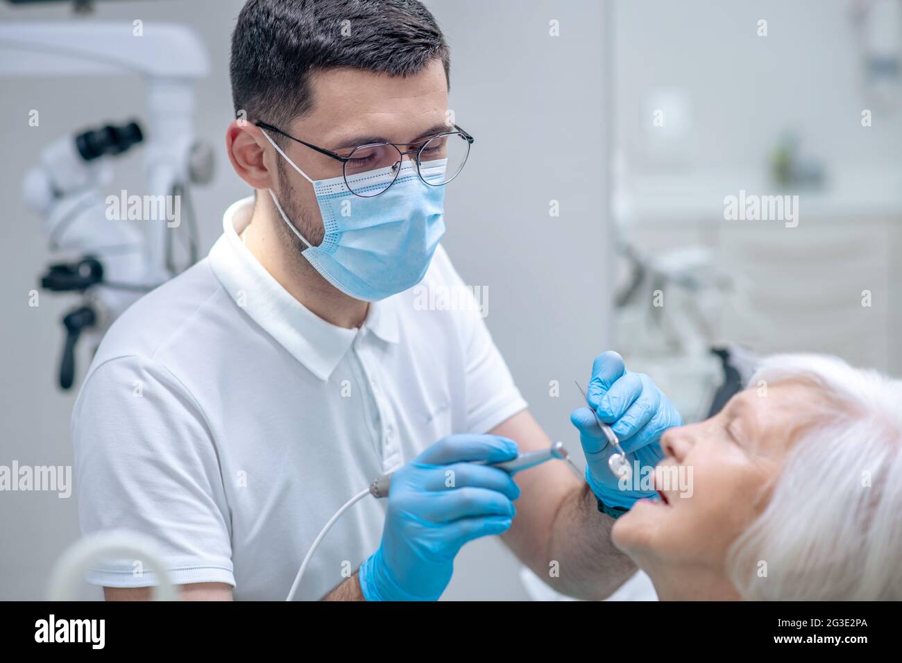 Dentist restoring teeth to the senior female patient Stock Photo - Alamy