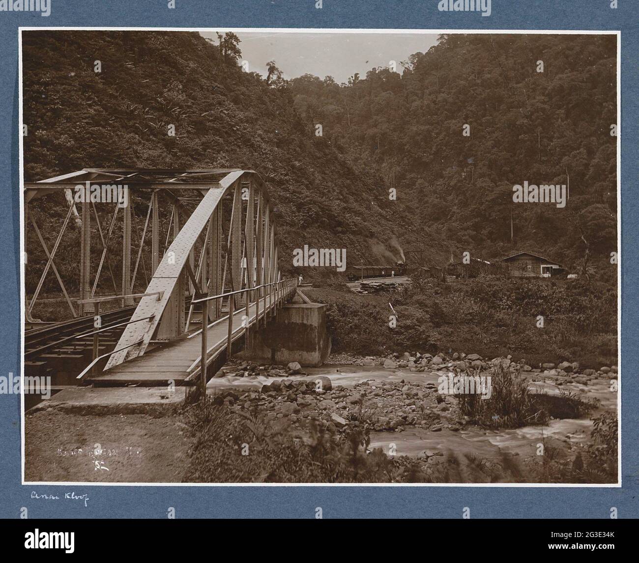 Track and pedestrian bridge at Kamp Tengah on Sumatra with a train in ...