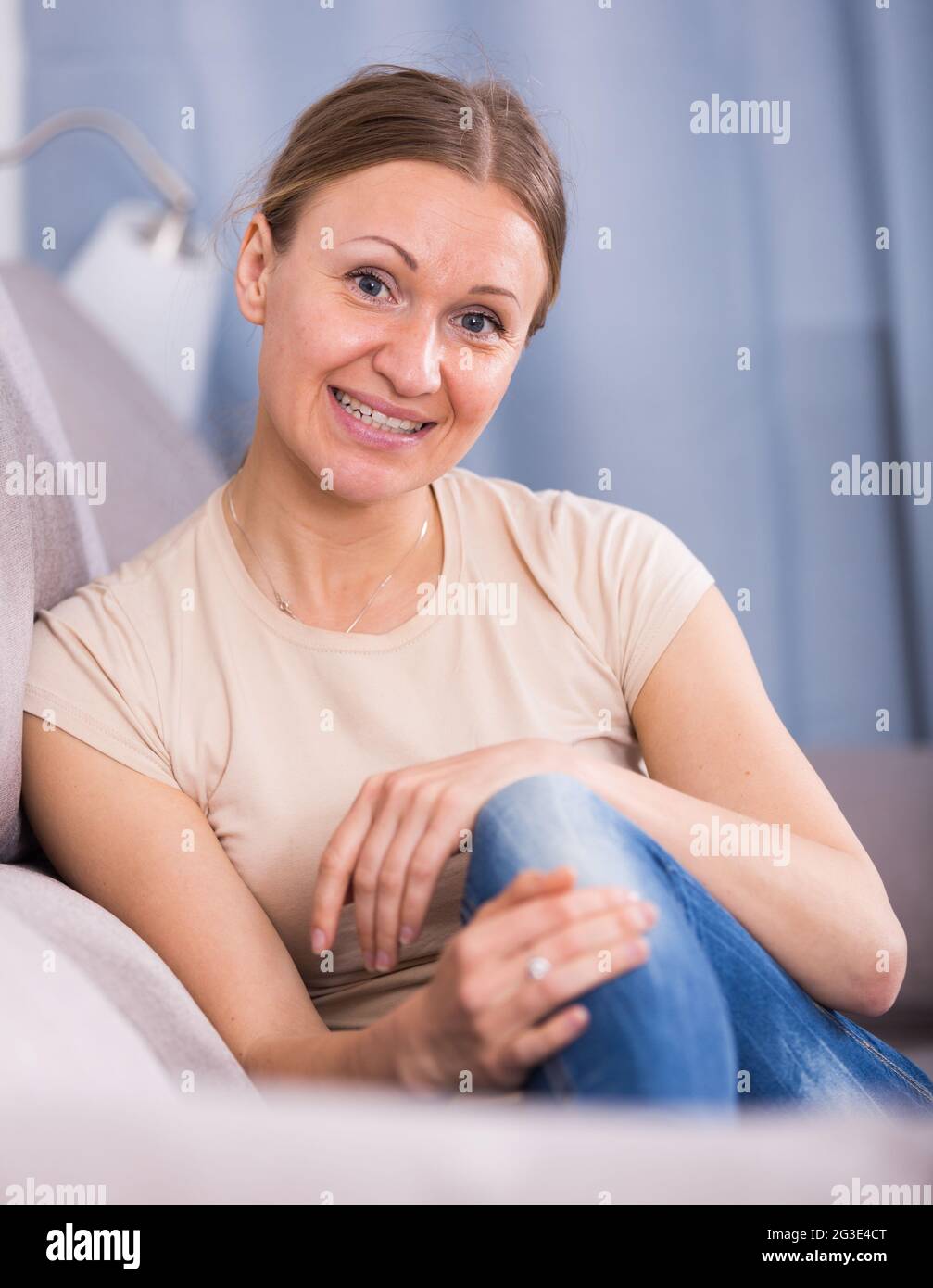 Positive woman relaxing on sofa Stock Photo - Alamy