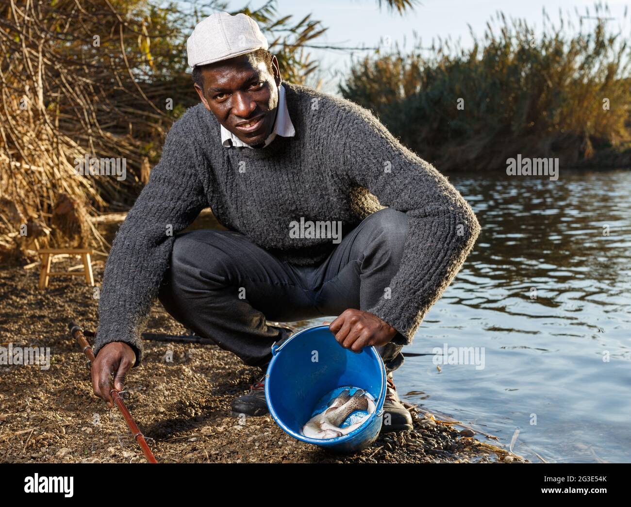 Fisherman removing caught fish Stock Photo - Alamy