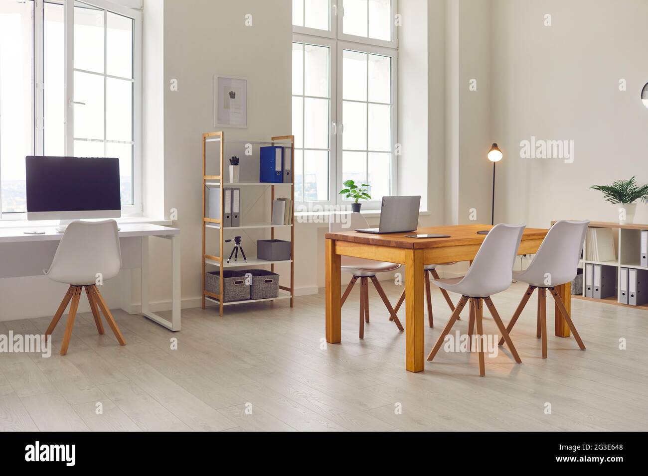 Side view of a bright office interior with modern tables, chairs and ...