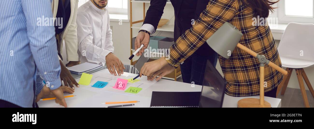 Diverse business team hands over office desk with color sticker ...