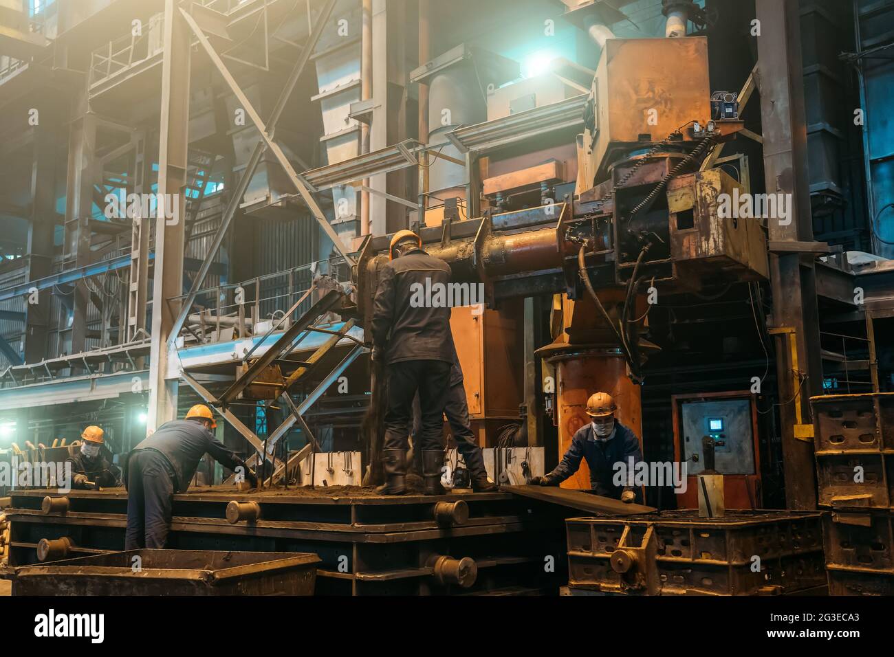 Workers work with molds for smelting iron at steel mill in factory ...