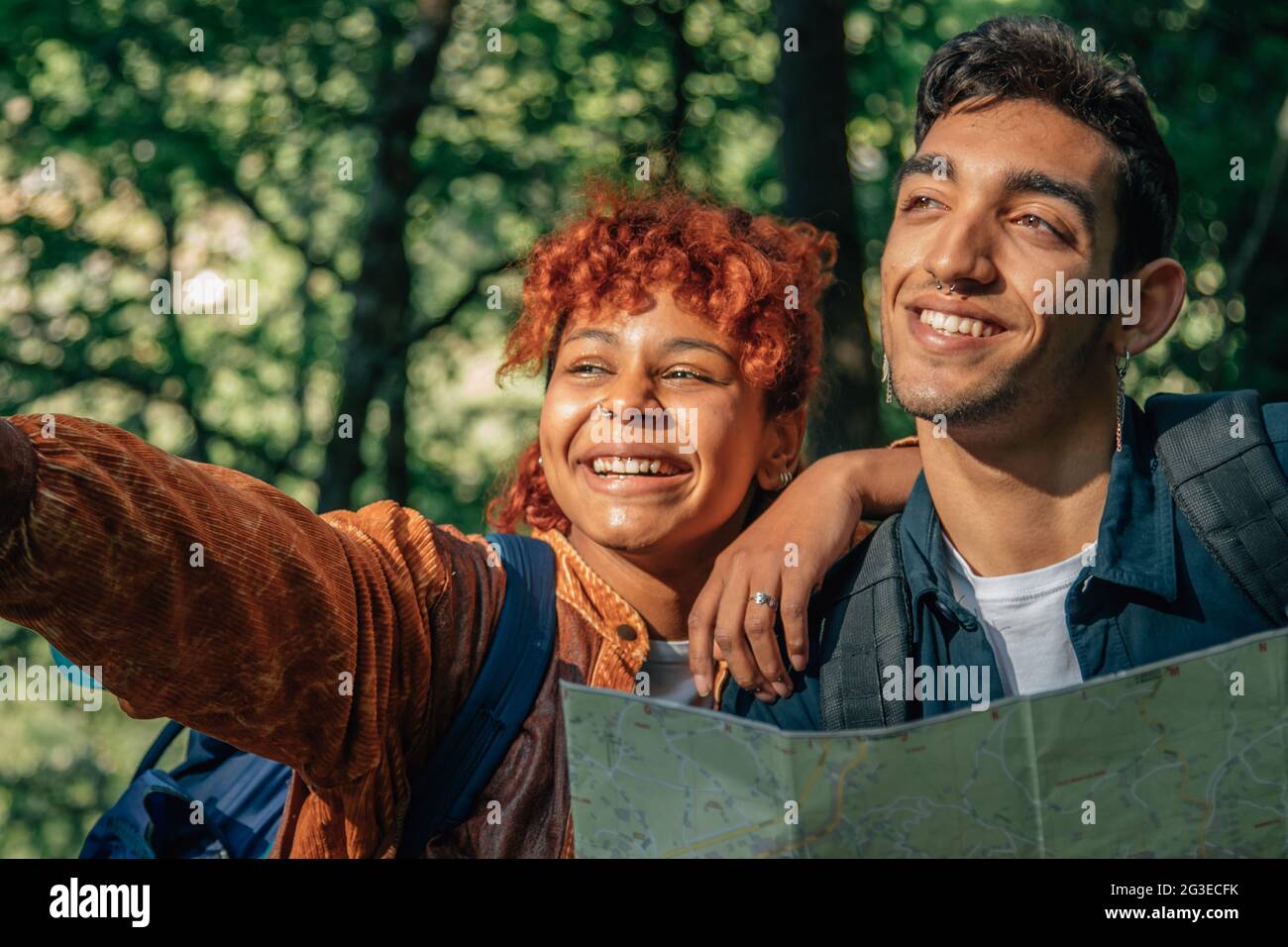multicultural young couple with map and travel backpack Stock Photo - Alamy