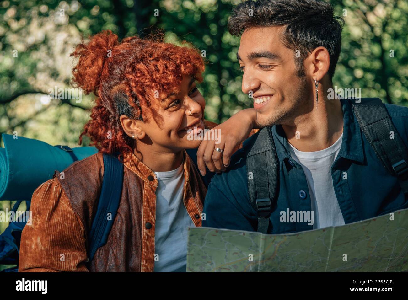 multicultural young couple with map and travel backpack Stock Photo - Alamy