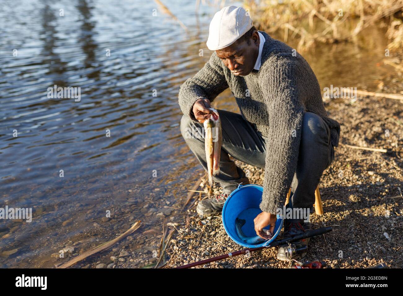 Fisherman holding fish in his hands Stock Photo - Alamy
