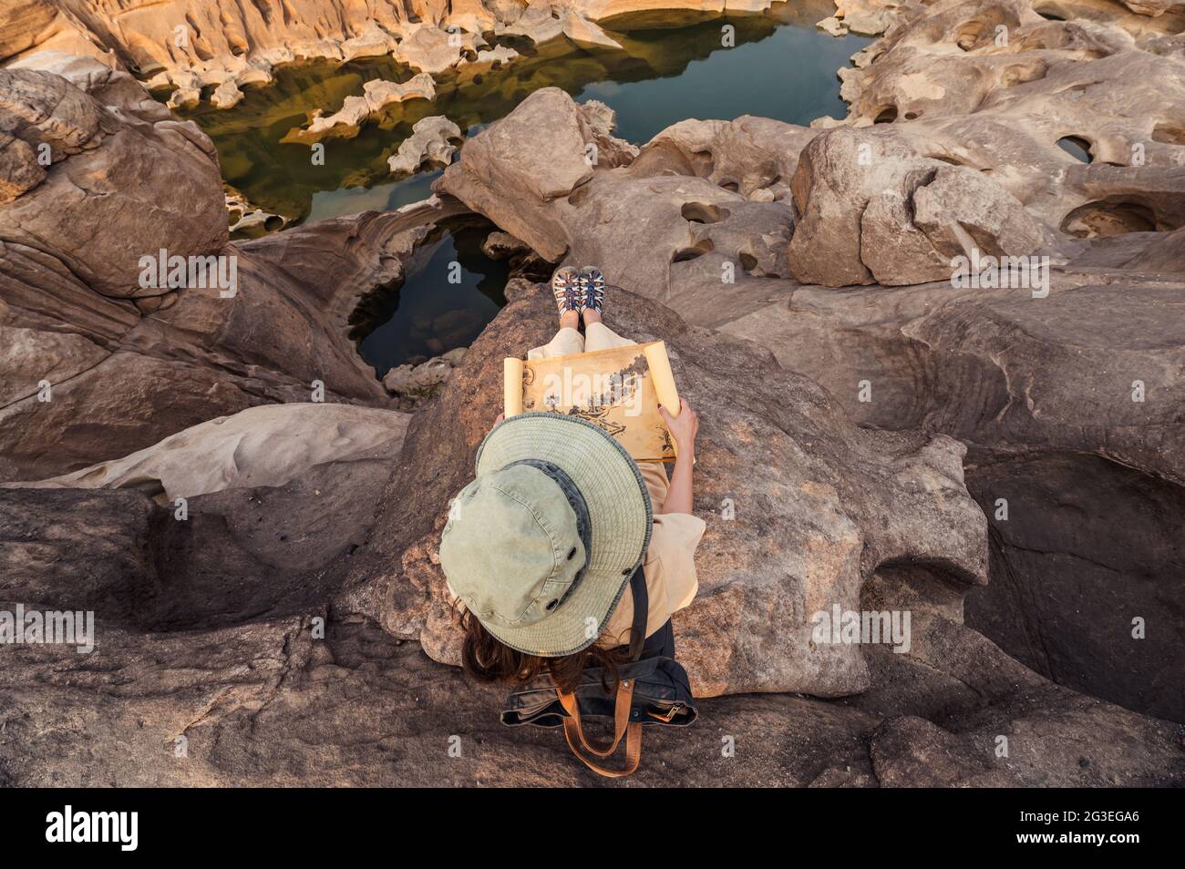 Explorer asian woman sitting on rock cliff with looking at paper map in ...