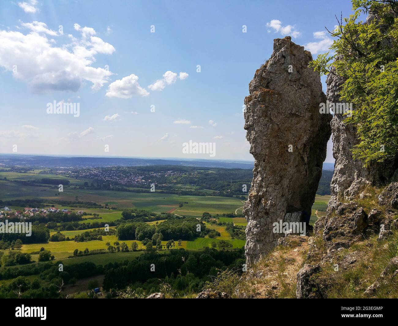 Rock on a background of blue sky with clouds and green valley with ...
