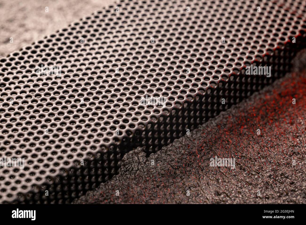 Black ventilation holes of a metal computer case. Aluminum grill close ...