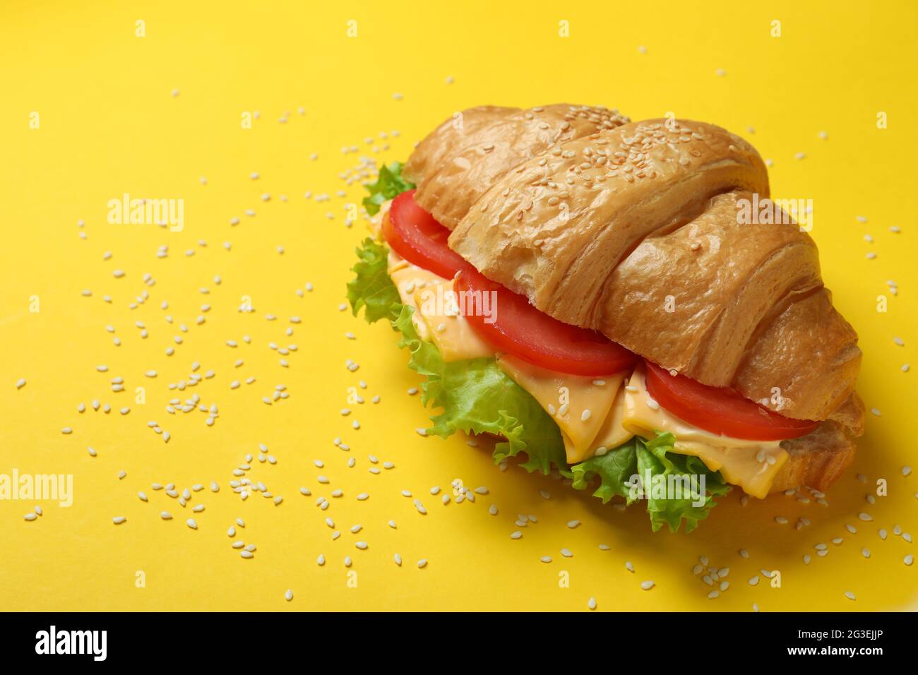 Tasty croissant sandwich on yellow background, space for text Stock ...