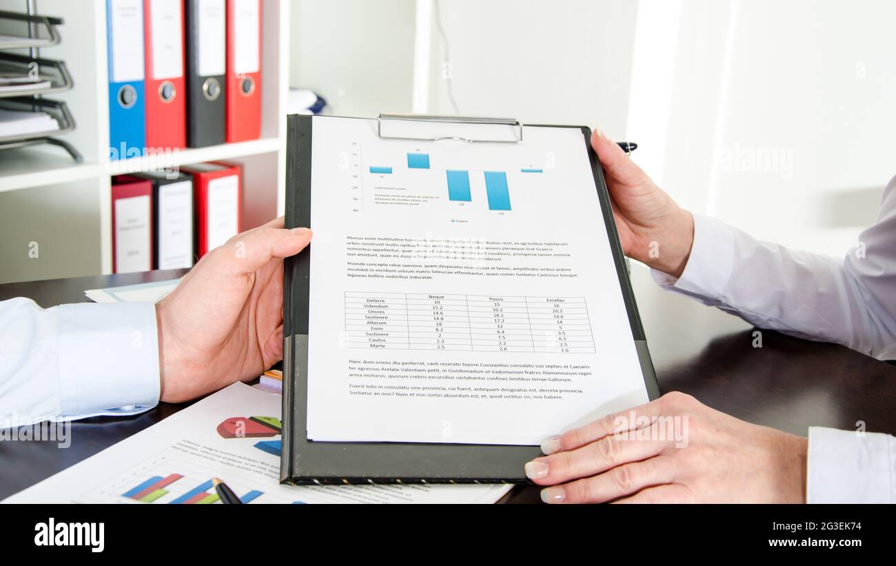 Two business people analyzing a chart Stock Photo - Alamy