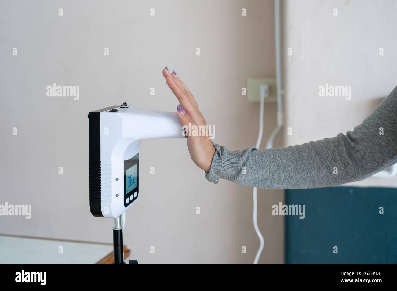 Palm of woman touchless measuring with automatic digital infrared ...