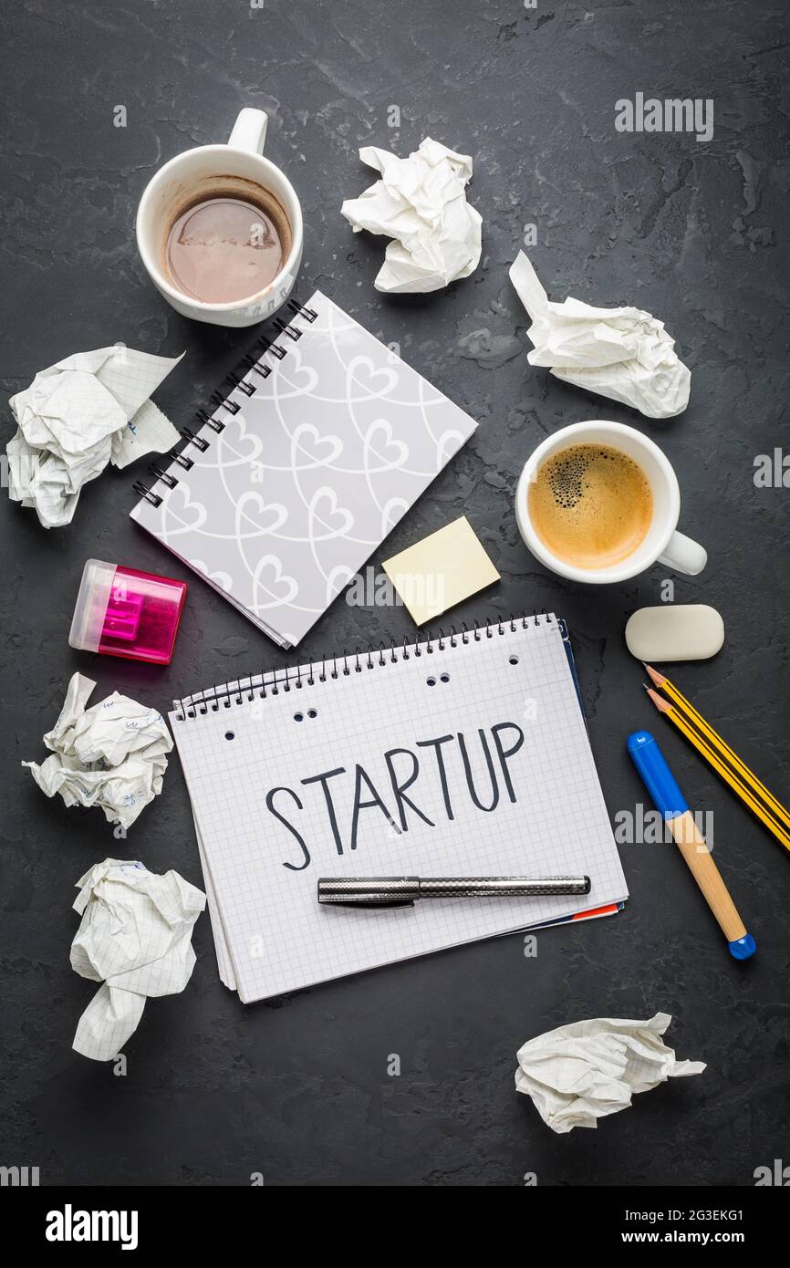 Startup concept - Notepad, coffee, discarded ideas and writing tools on ...
