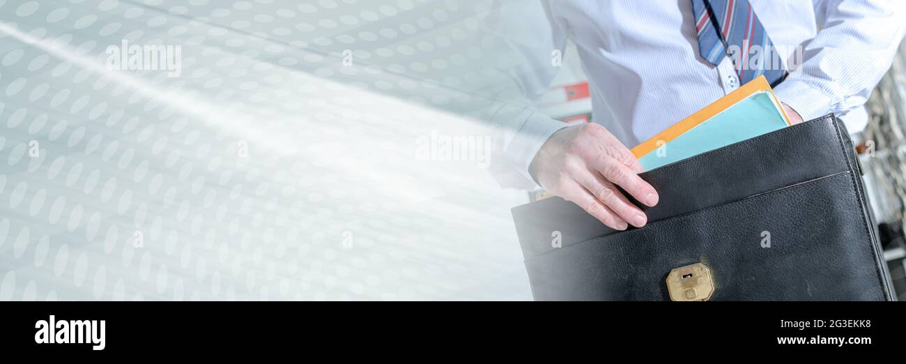 Businessman pulling out folders from his briefcase at office; panoramic ...