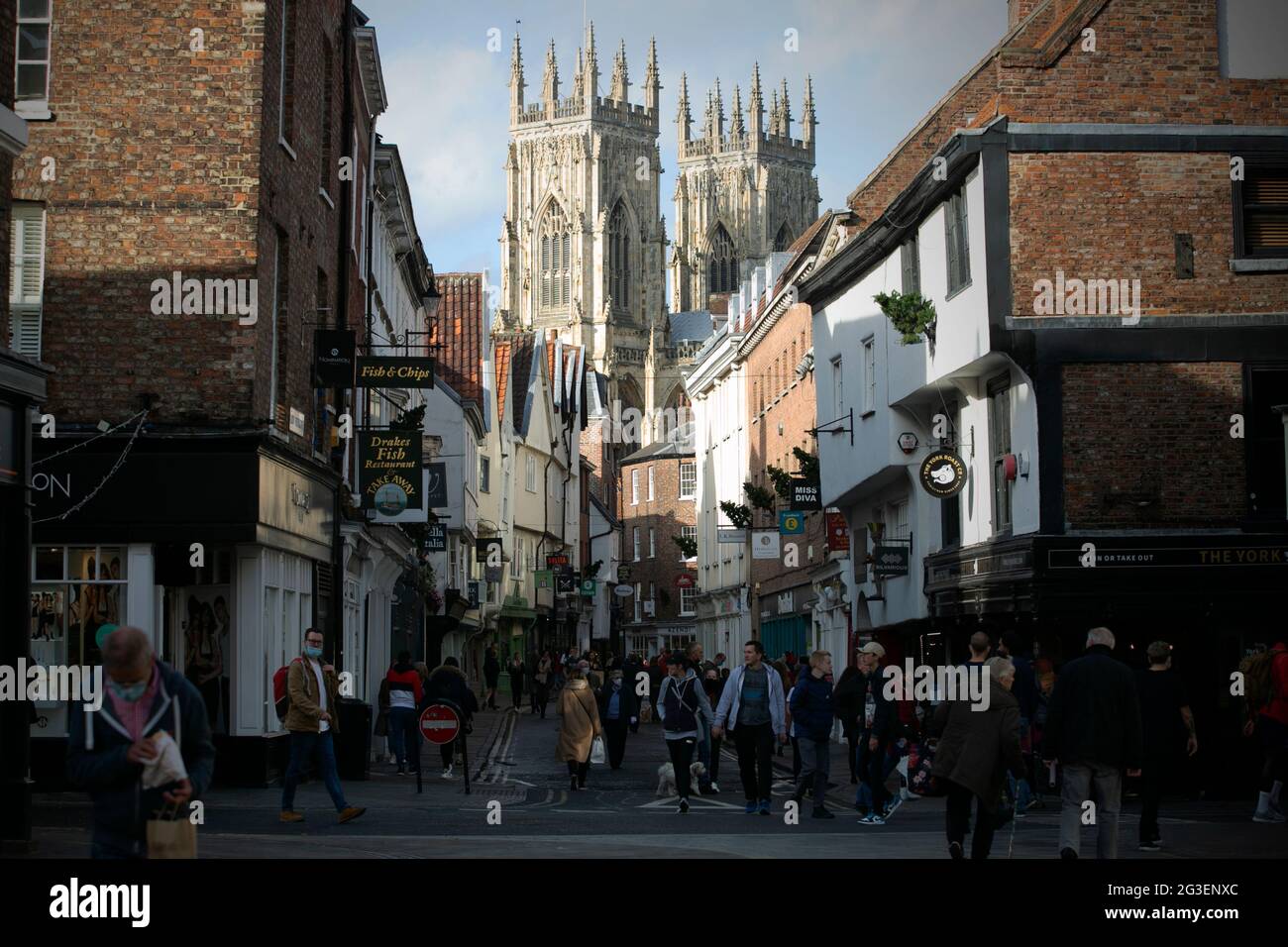 York Minster towers above people strolling along the streets in the ...