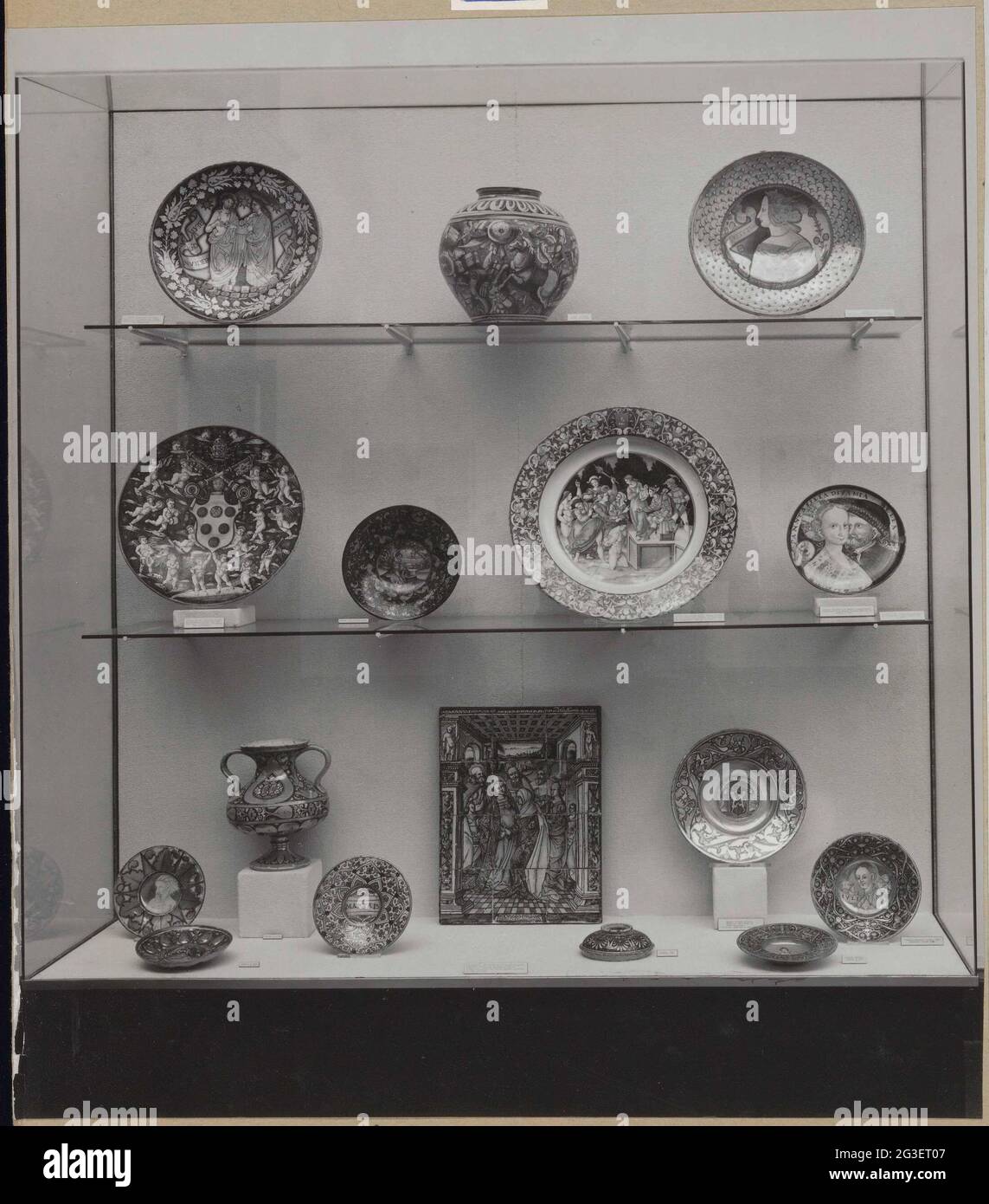 Showcase with various objects including dishes, vases and a tile ...