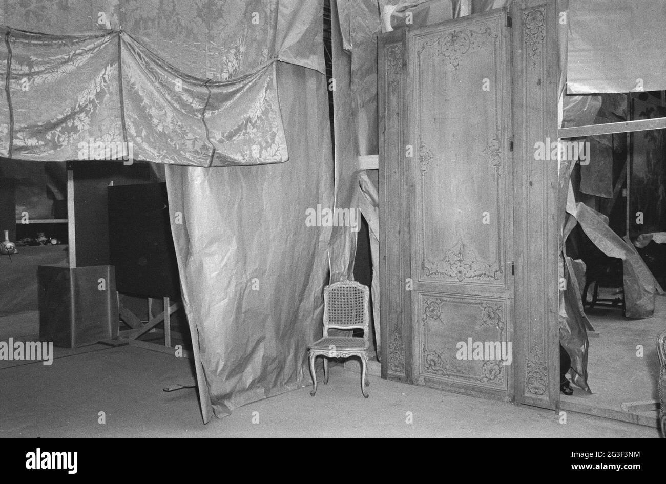 Paneling with armchair against background of pieces of dust or sheets ...