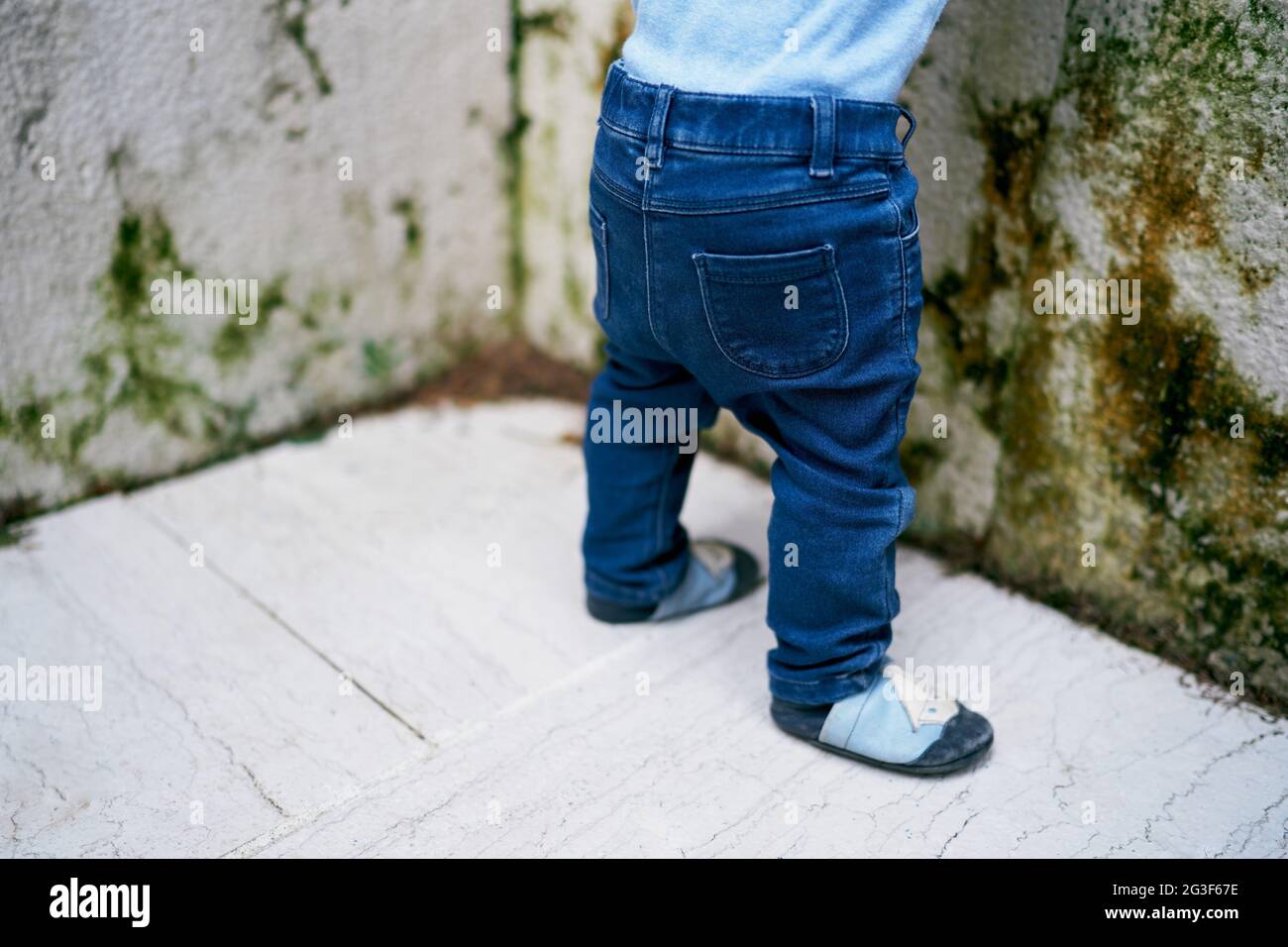 Baby's feet on the paving slabs near the stone fence. Close-up Stock ...