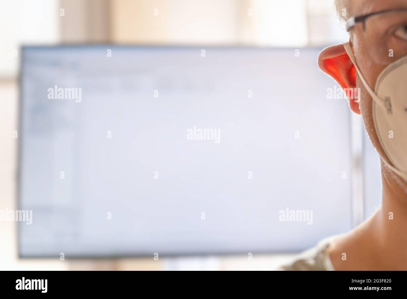 Sail ears of a man in the office by wearing a mask Stock Photo - Alamy