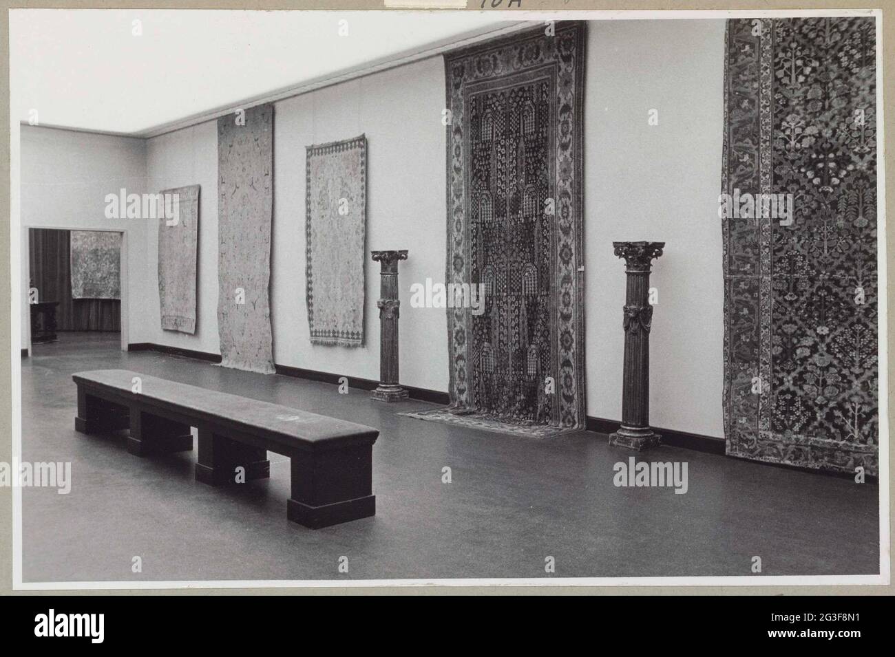 Room with five carpets and columns; Exhibition Oriental rugs. In ...