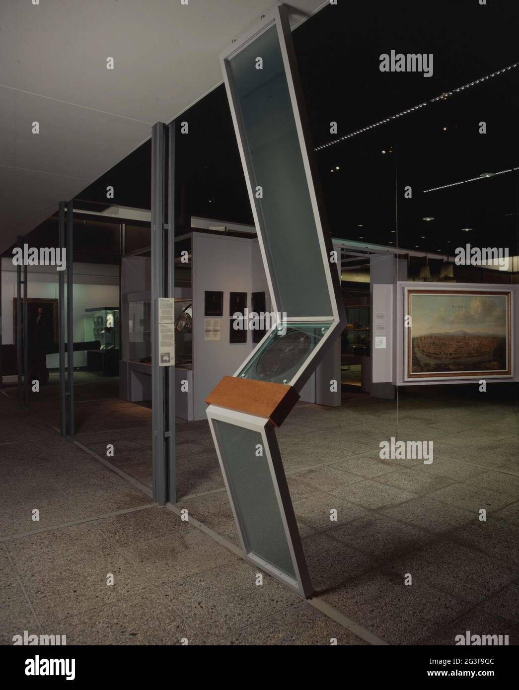 Room with map caught in glass panel, portraits and painting of city ...