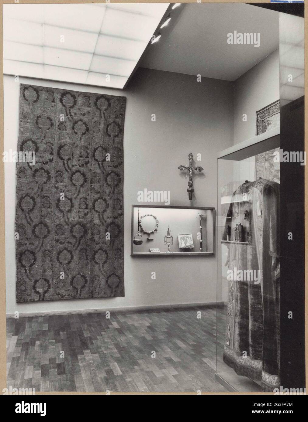 Room with tapestries, a crucifix and showcases with liturgical objects ...